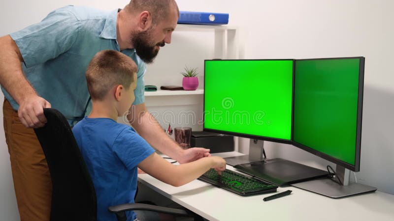 Two Computers with Green Screen. Elementary School Student an His ...