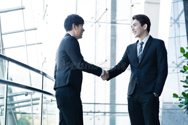 Confident Businessmen Shaking Hands and Smiling Stock Photo - Image of ...