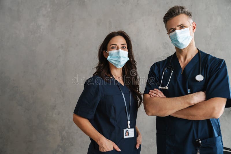 Two Confident Doctors in Medical Masks Standing Stock Photo - Image of ...