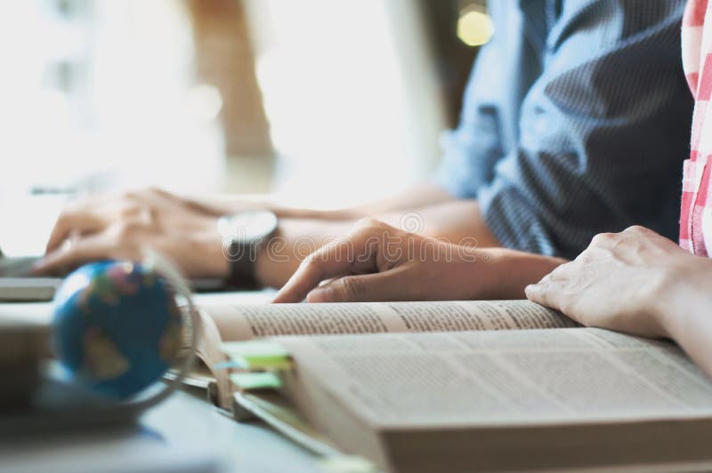 Two Confident Students Reading a Book or Doing Homework Together while ...
