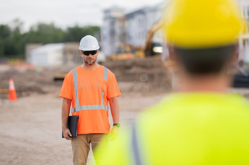 Two Construction Site Workers in Helmet Work Outdoors. Builders Workers ...