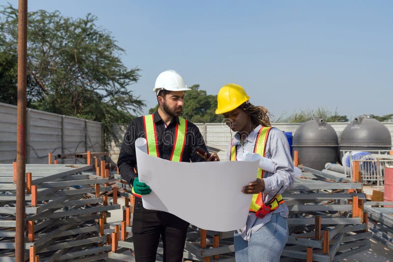 Two Construction Worker Discussing Work while Holding. Construction ...