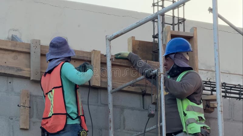 Two Construction Workers Assembling Scaffolding at a Worksite. Stock ...