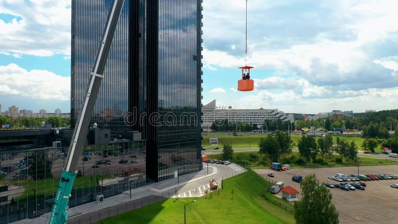 Two Construction Workers in the Building Cradle of a Mobile Crane ...