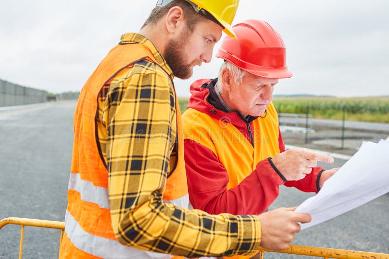 Two Construction Workers with Construction Drawing for the House ...