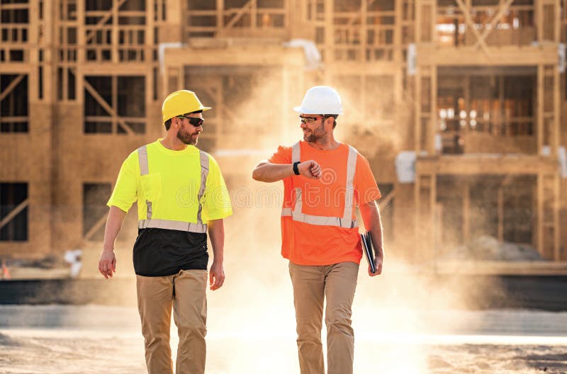 Two Construction Workers with Hardhat Helmet on Construction Site ...