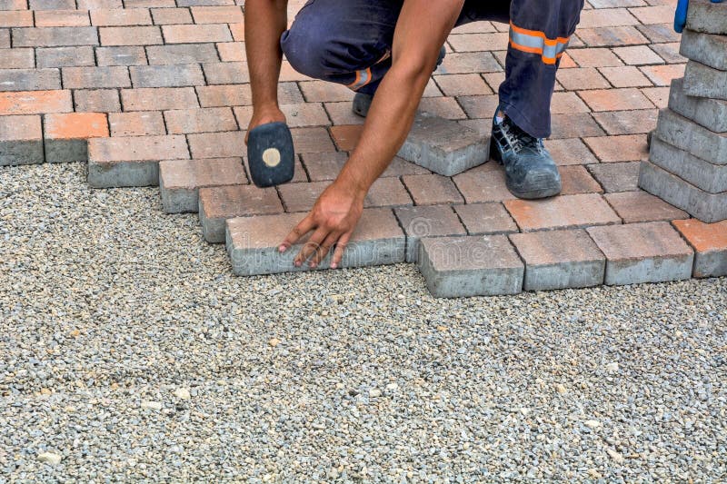Two Workers Putting the Bricks on the Ground in Front of a Brick ...