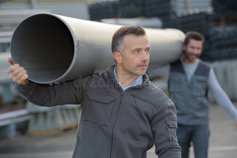 Two Construction Workers on Site Holding Pipe Stock Photo - Image of ...