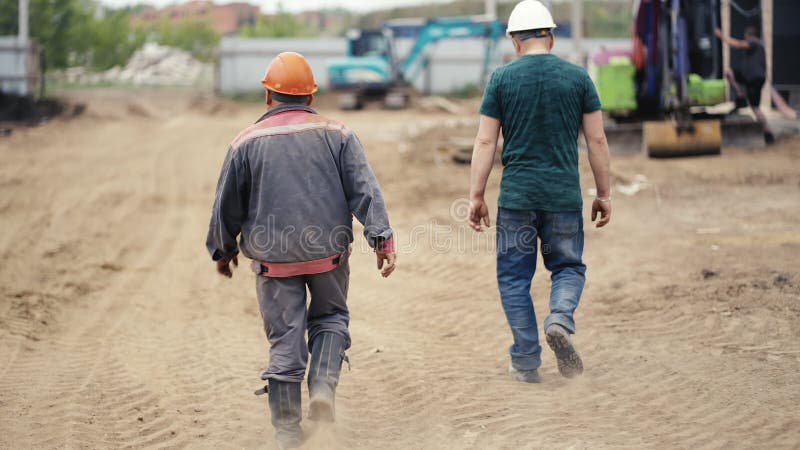 Construction Workers Walking on a Job Site Undergoing Various Tasks and ...