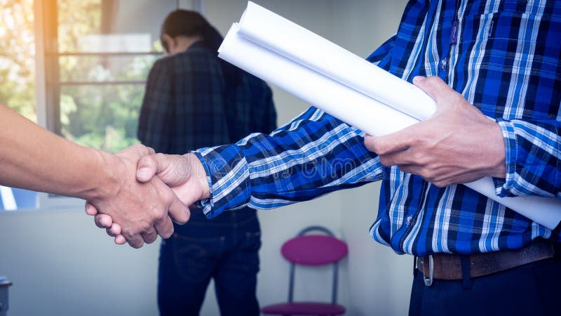 Two Contractor Engineers Hand in Hand with the Background Where People ...