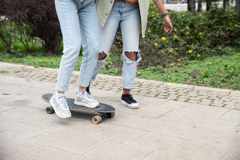Two Cool-looking Hipster Friends in Park Learning To Ride a Skateboard ...