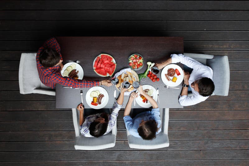 Two couples eating dinner stock photo. Image of sitting - 58400514