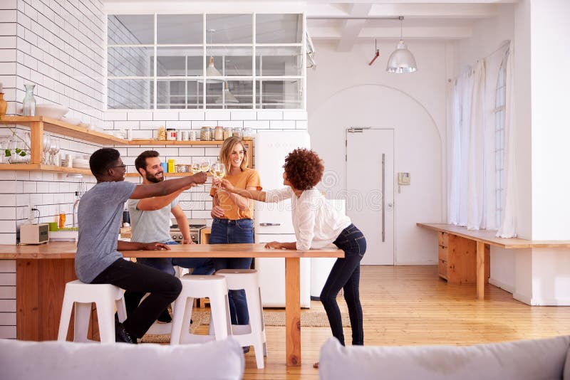 Two Couples Relaxing in Kitchen at Home Making a Toast with Glass of ...