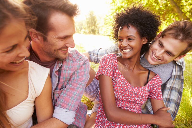 Two Happy Couples Embracing and Smiling To Camera Outdoors Stock Photo ...