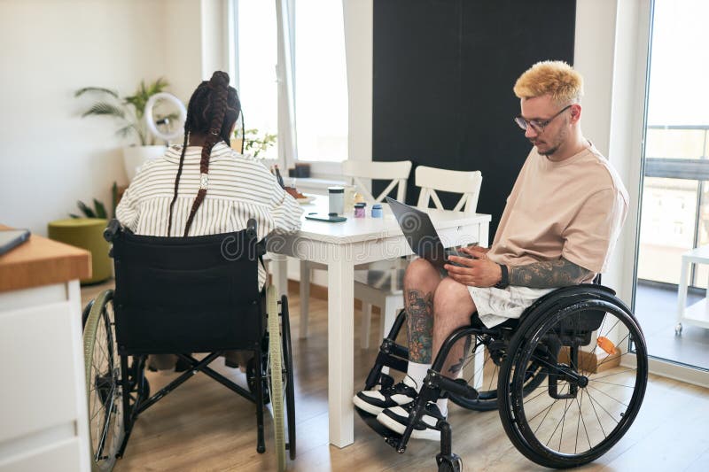 Collaborating in Modern Office Space with Wheelchair Users Stock Photo ...