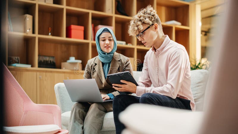 Two Creative Colleagues Collaborating Over a Work Project Using ...