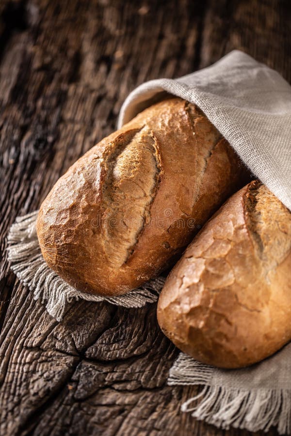 Two Crispy Loafs of Bread Covered in a Table Cloth on a Vintage Wooden ...
