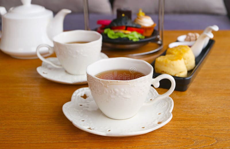 Two Cups of Hot Tea with Blurry Scones and Afternoon Tea Pastries Stock ...