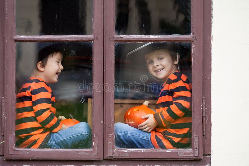 Two Cute Boys, Sitting on a Window with Jack-o-lantern Stock Image ...