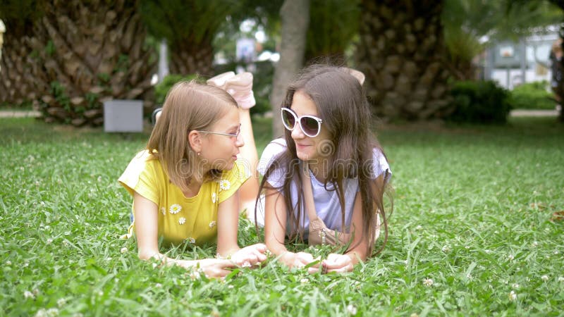 Two Cute Girls Relax in the Park on the Grass Stock Image - Image of ...