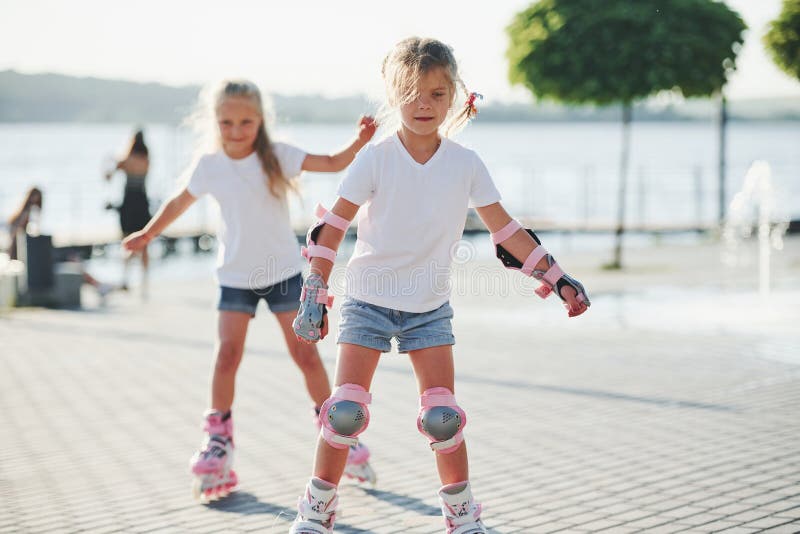 Two Cute Kids Riding by Roller Skates in the Park at Daytime Stock ...