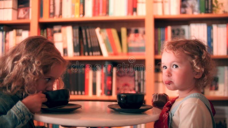Two Cute Little Girls Having Breakfast in a Library or Book Cafe Stock ...