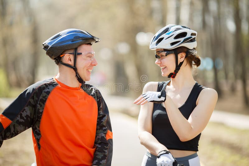 Two cyclists stand at park stock image. Image of biking - 235962989