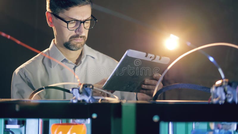 Two 3D Printers Work with Vases while a Man Controls Them. Engineer ...