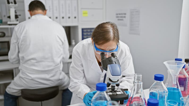 Two Dedicated Scientists, Team Mates Working Together Indoors in a Lab ...