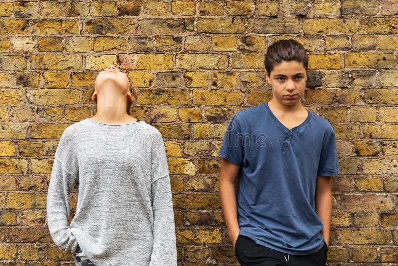 Two Depressed Young Teens Stand in Front of a Brick Wall Stock Image ...