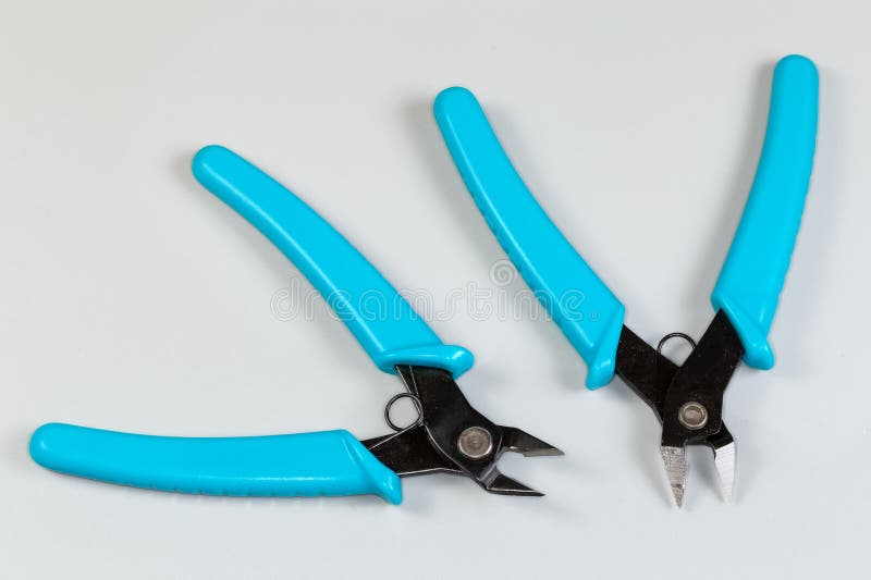 Two Diagonal Nippers with Blue Insulated Handles on Gray Background ...