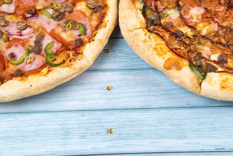 Two Different Delicious Big Pizzas on a Blue Wooden Background Stock ...