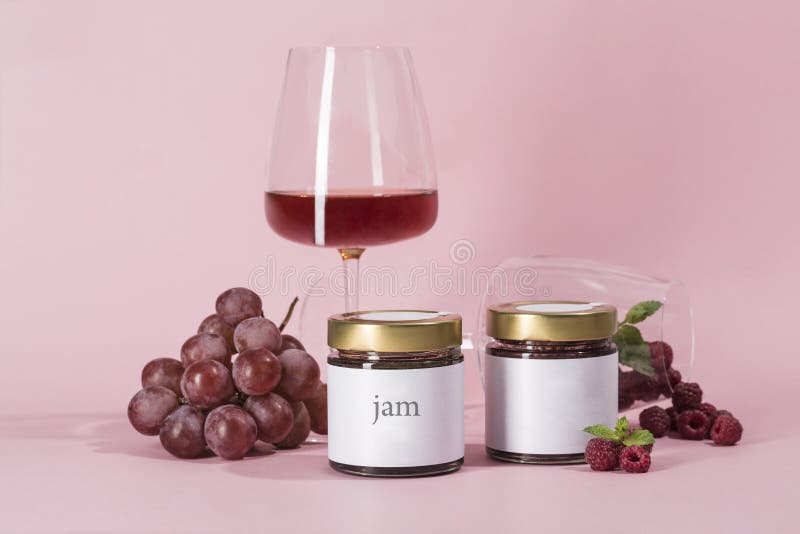 Two Different Raspberry and Grape Jams in Jars with a Glass of Wine on ...