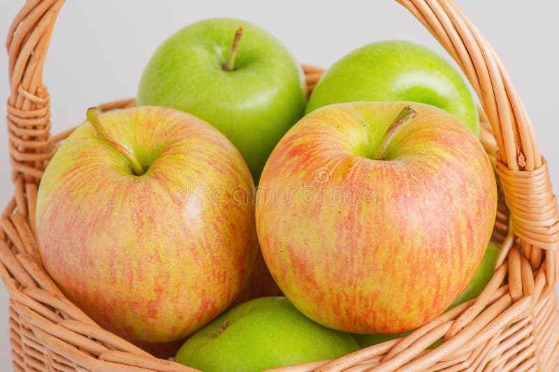 Two Different Varieties of Apples in a Wicker Basket on a Gray ...