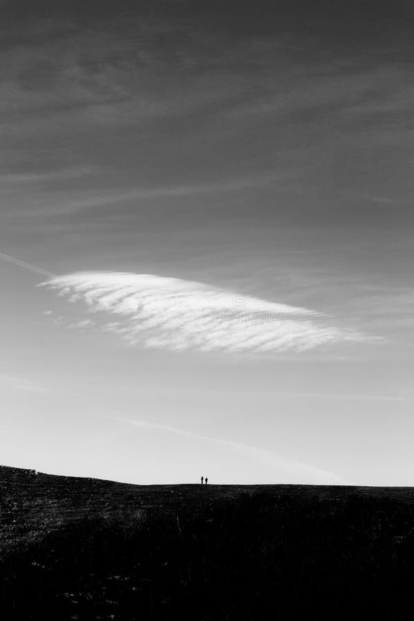 Two Distant People on a Mountain Peak with a Cloud Above Them Stock ...