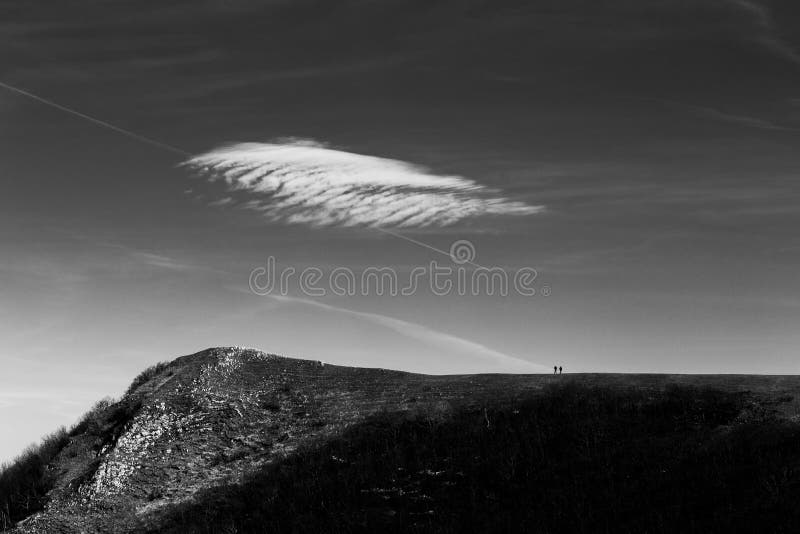 Two Distant People on a Mountain Peak with a Cloud Above Them Stock ...