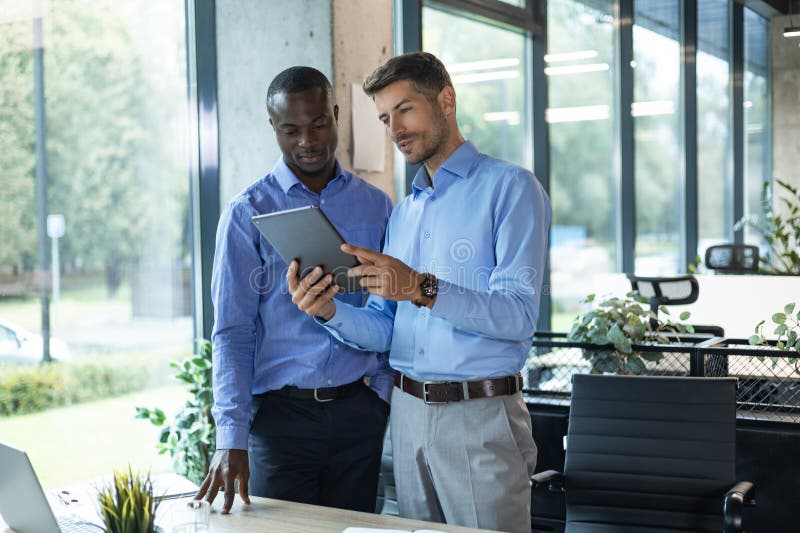 Two Diverse Business Partners Standing and Discussing Project Working ...
