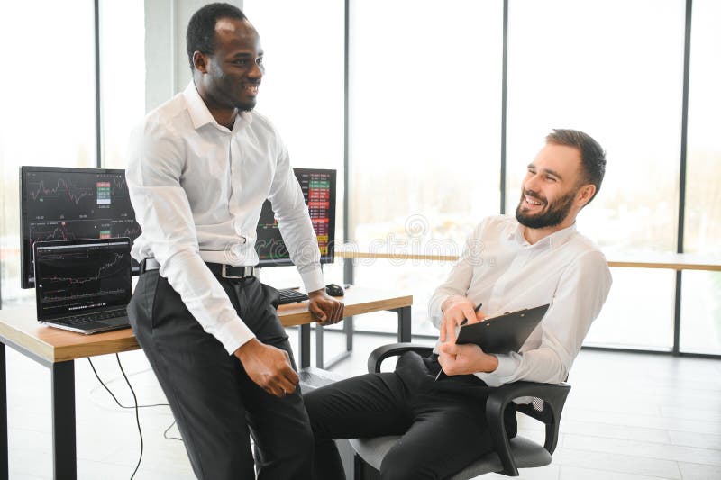 Two Diverse Colleagues Traders Talking To Each Other, Sitting in the ...