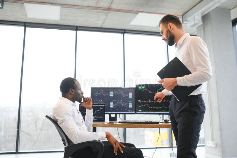 Two Diverse Colleagues Traders Talking To Each Other, Sitting in the ...