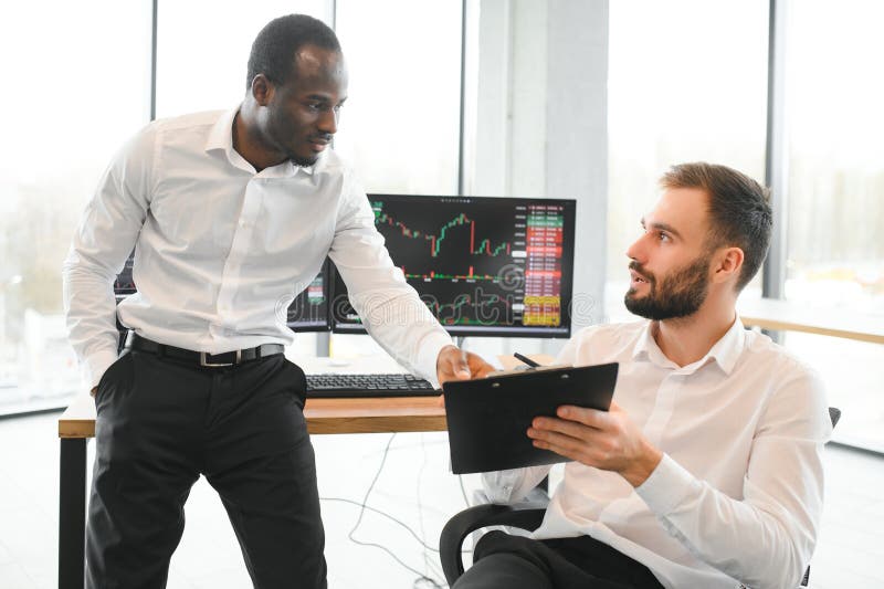 Two Diverse Colleagues Traders Talking To Each Other, Sitting in the ...
