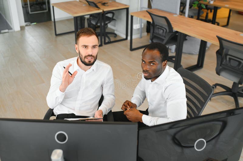 Two Diverse Colleagues Traders Talking To Each Other, Sitting in the ...