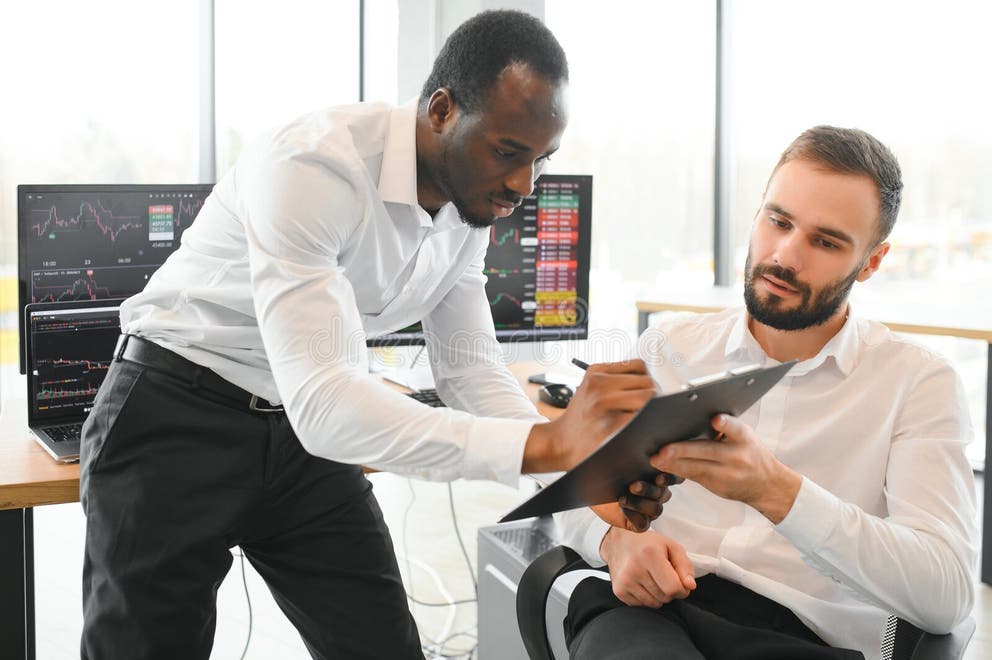 Two Diverse Colleagues Traders Talking To Each Other, Sitting in the ...