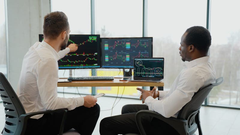 Two Diverse Colleagues Traders Talking To Each Other, Looking at Graphs ...