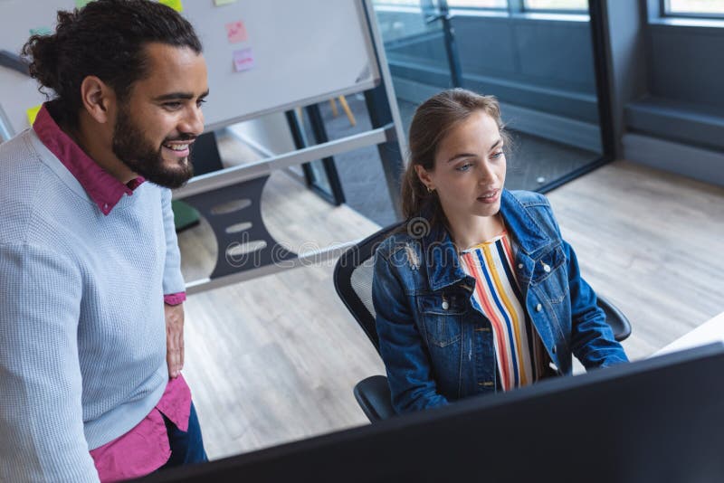 Two Diverse Creative Colleagues Sitting at Desk Using Computer and ...