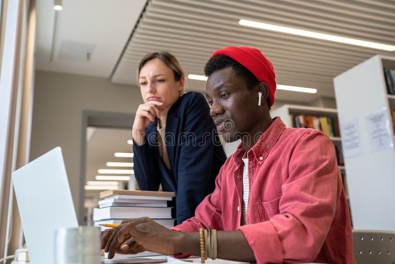 Two Diverse Students Study Partners Learning Together in Library, Using ...