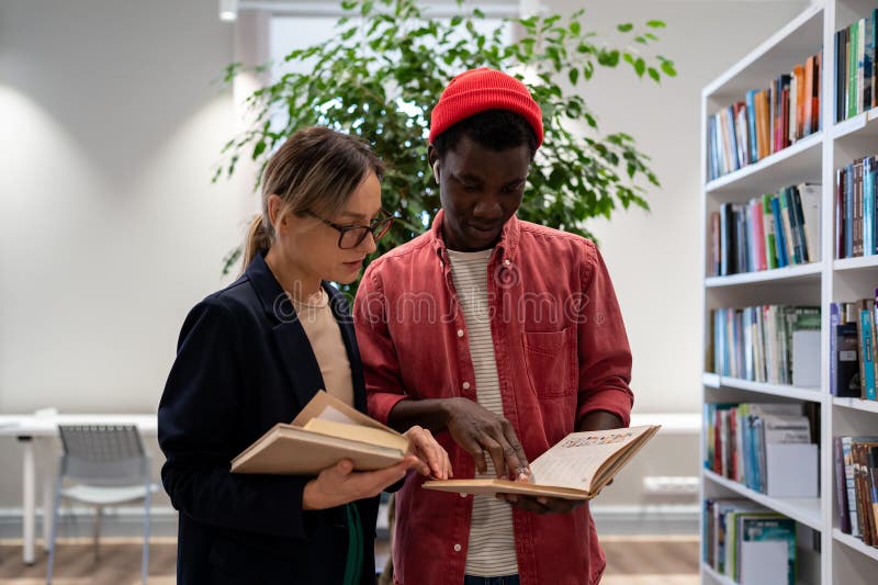 Two Diverse University Students Studying Together in University Library ...