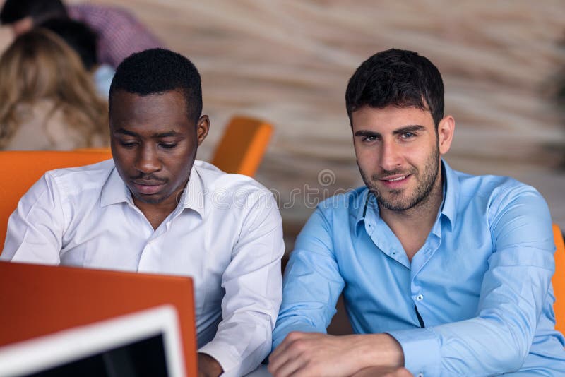 Two Diverse Work Colleagues Smiling while Sitting Together in an Office ...