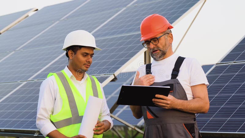 Two Diverse Workers Engineers Talking with Each Other while Holding a ...