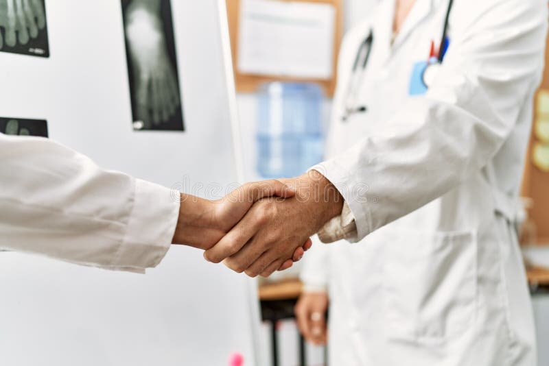 Two Doctor Celebrating Achievement with Handshake at the Clinic Office ...