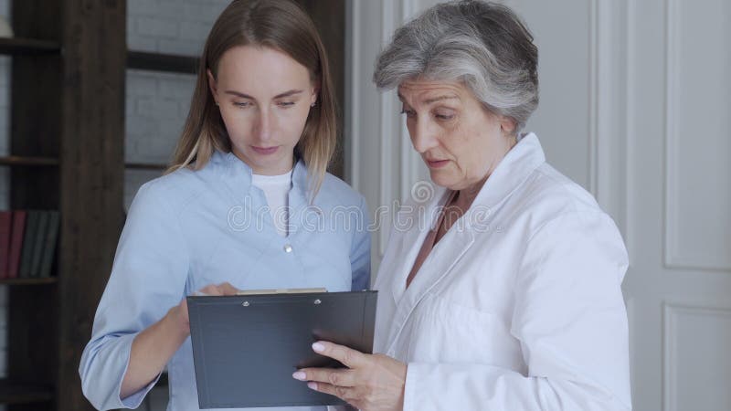 Two Doctors Communicate with Each Other in a Medical Office in a ...